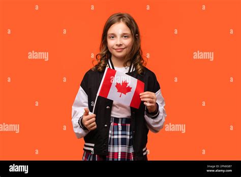 Girl Wearing In School Outfit And Holds Small National Flag Of Canada