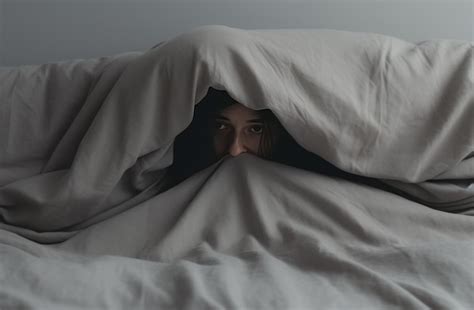 Premium Ai Image A Person Hiding Under A Blankets In A Bed