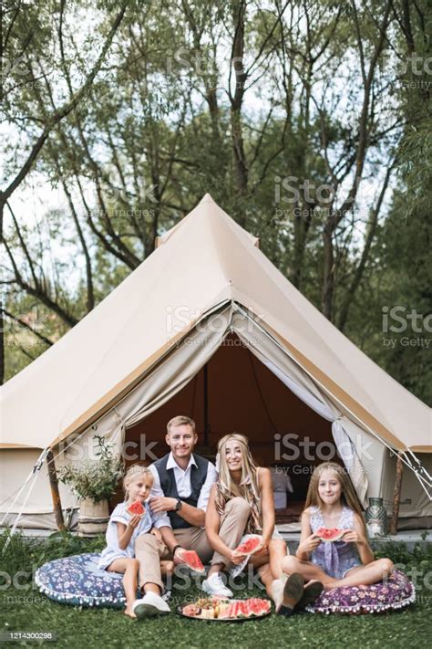 여름에 아이들을 동반한 부모는 공원에서 즐거운 시간을 보세요 녹색 잔디에 앉아 수박을 먹는 피크닉에 귀여운 행복한 가족 여름 방학 가발 근처에 앉아 있는 가족 가족에 대한