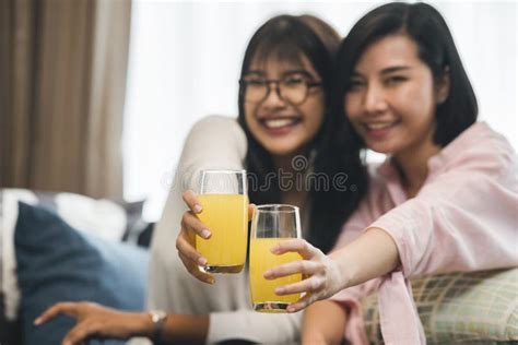Two Asian Women Drink Orange Juice In Living Room Stock Image Image