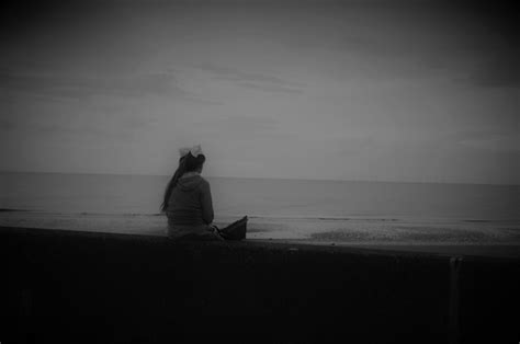 Premium Photo Rear View Of Girl Sitting On Beach Against Sky
