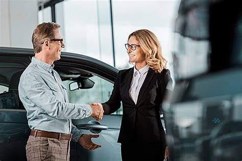 유토이미지 Adult Customer And Female Car Dealer Shaking Hands At Showroom