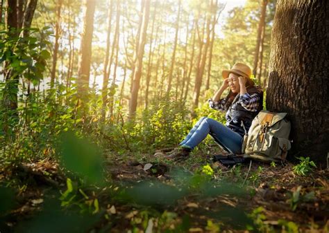 Premium Photo Woman With Headache Sitting Against Trees In Forest
