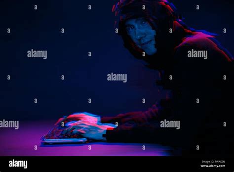 hacker in the hood working with computer typing text in dark room
