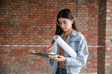 Notepad In Hands Young Woman Is Standing In The Unfinished Building On
