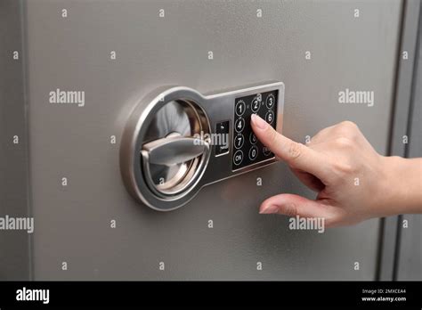 Woman Entering Code On Keypad Of Modern Safe Closeup Stock Photo Alamy