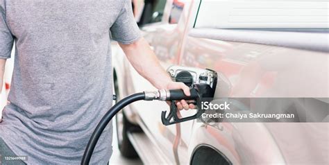 흰색 백인 자동차 소유자는 검은 연료 노즐을 들고 주유소에서 자동차 탱크에 높은 에너지 전력 연료를 채우고 벤진 디젤 Gasohol 가솔린에 대한 상업 서비스 가솔린에 대한