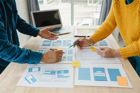 Ux 개발자와 Ui 디자이너가 현대 사무실에서 고객 요약 및 색상 코드와 함께 테이블에 모바일 앱 인터페이스 와이어프레임