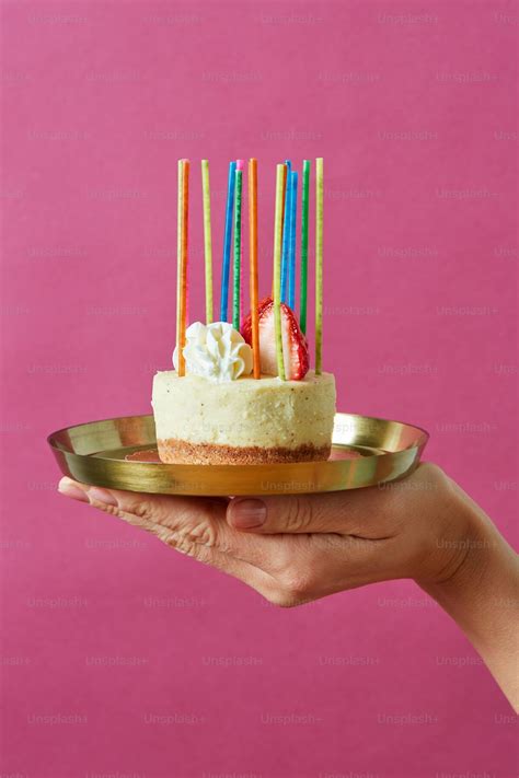 촛불이 든 케이크가 든 접시를 들고 있는 손 사진 Unsplash의 파티 이미지