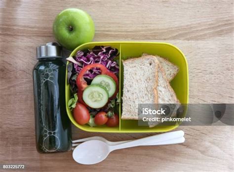 곡물 빵과 녹색 야채와 과일 주스 병 나무 배경에 건강 한 점심 상자 건강 다이어트 개념에 대 한 깨끗 한 음식과 식습관 평면도