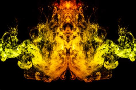 검은 고립 된 배경에 머리 얼굴과 눈의 모양에 공포의 형태로 다른 녹색 노란색 오렌지와 붉은 색의 연기의 추상적 인 이미지 신비한 상징의 영혼과 유령 0명에 대한 스톡 사진