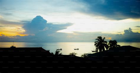 바다에 해가 지고 있고 배가 물 속에 떠 있습니다 사진 Unsplash의 해질녘 이미지