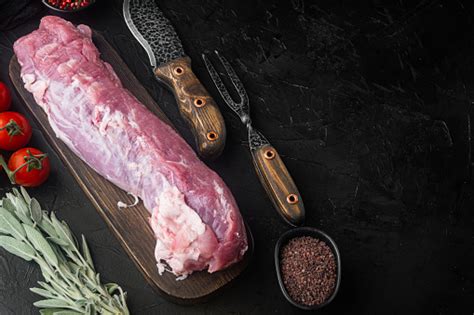 바베큐 나이프와 고기 포크 검은 돌 배경 카피 스페이스와 텍스트 공간을 가진 나무 도마에 재료와 허브와 함께 원시 돼지 고기 허리 0명에 대한 스톡 사진 및 기타 이미지