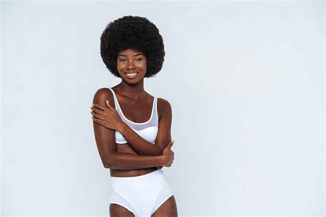 Skinny Female Model Wearing Lingerie With Arms Crossed Standing Against