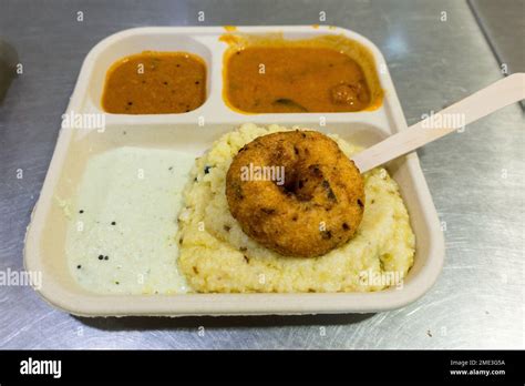 A Plate Of Pongal And Vada With Chutney And Sambar In Disposable Environment Friendly Plate