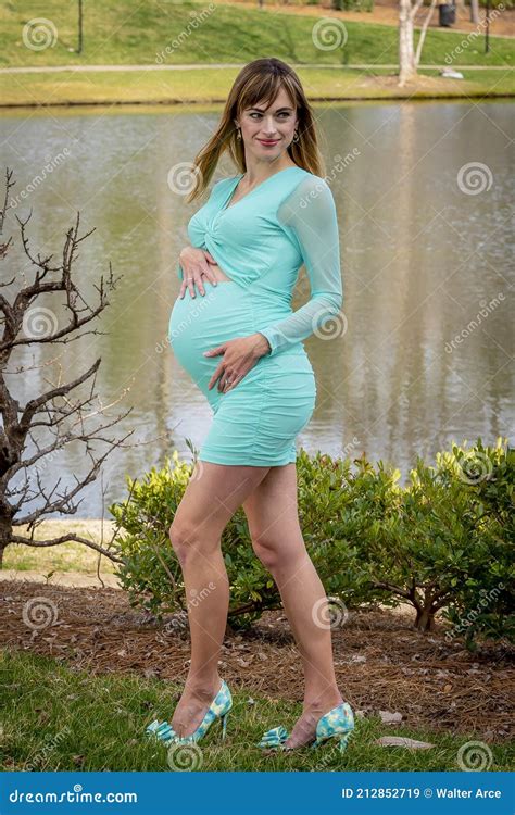 A Gorgeous Glowing Pregnant Woman Poses In An Outdoor Environment Stock