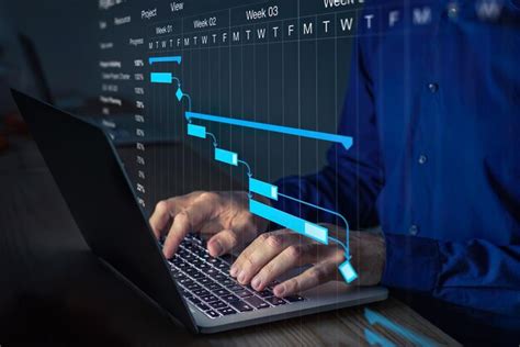 Gantt 차트에서 작업하는 프로젝트 관리자는 팀 작업을 조정하는 사람과 함께 컴퓨터 화면의 팀 관리 다이어그램에 대한 일정 작업 및 이정표 진행 상황을 업데이트합니다