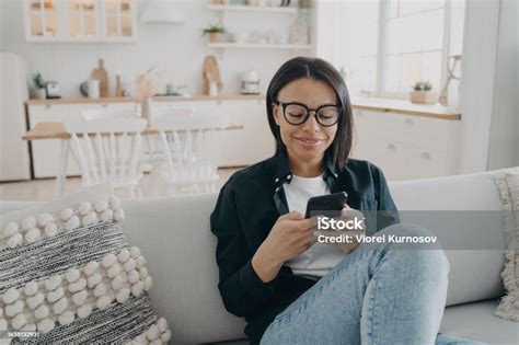 웃는 여자는 소셜 네트워크에서 스마트폰 채팅 온라인 쇼핑 집에서 소파에 앉아 사용 서비스에 대한 스톡 사진 및 기타 이미지 서비스 스마트폰 30 34세 Istock