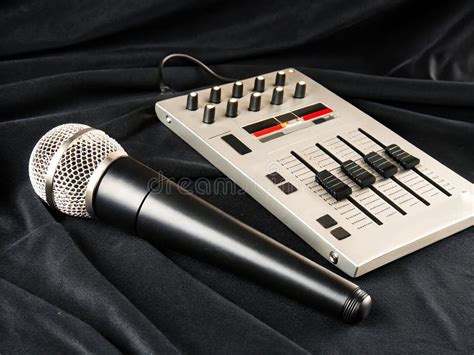 Black Wireless Microphone And Sound Equalizer Placed On A Black Cloth