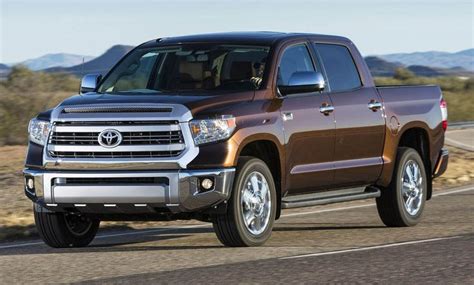 تويوتا تاندرا شاحنة بيك آب بنيّة تسير على الطريق مع جبال في الخلفية