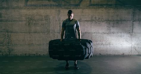 백인 근육질의 남자가 체육관 훈련에서 타이어를 들어 올리고 있다 당신을 파괴하는 것을 파괴하십시오 사진 Unsplash의 네덜란드 이미지