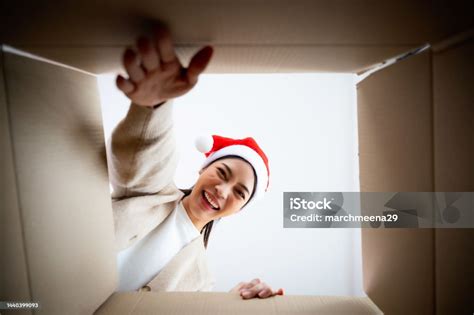 크리스마스 모자를 쓰고 선물 상자의 포장을 푸는 행복한 젊은 아시아 여성 아름다운 여성은 선물을 열고 내부를 보면서 웃고 놀랐다 새해 복 많이 받으세요 메리 크리스마스와