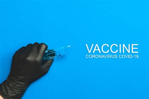 예방 접종 병 의료 용 장갑에 의사의 손 보호 독감 바이러스와 코로나 바이러스에 대한 바늘 주사위를 개최 파란색으로 분리된 코비드 백신 유리병 복용량 독감 주사 약물 바늘