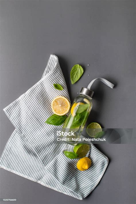 회색 배경에 과일 라임 레몬 바질 잎 줄무늬 수건이 있는 물 한 병이 놓여 있습니다 건강과 웰빙 개념 0명에 대한 스톡 사진 및 기타 이미지 Istock