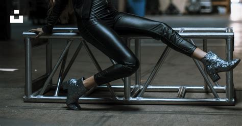 검은 가죽 재킷과 검은 바지를 입은 여자가 바 좌석에 앉아 있다 사진 Unsplash의 무료 초상 이미지