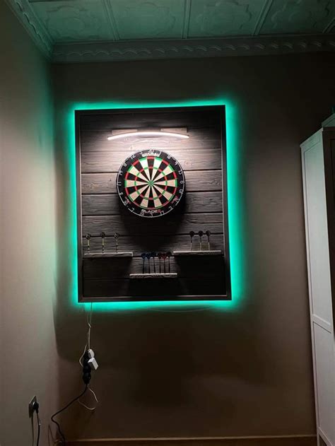 A Dart Board Mounted To The Side Of A Wall Next To A Neon Green Light