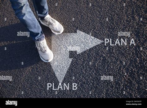 Choosing Between Plan A And Plan B Man Near Pointers On Road Closeup