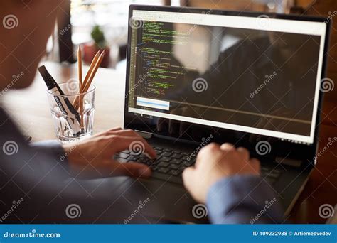 Back View Over The Shoulder Shot Of Developer Programmer With Laptop Program Code And Script