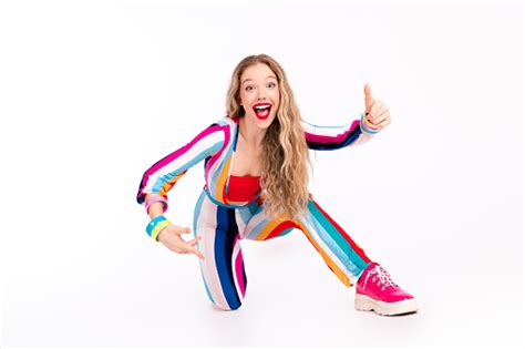 화려한 줄무늬 의상을 입은 활기찬 젊은 여성이 흰색 배경에 엄지 손가락을 치켜 들고 활기차게 포즈를 취하고 있습니다 16 17 살에 대한 스톡 사진 및 기타 이미지 Istock