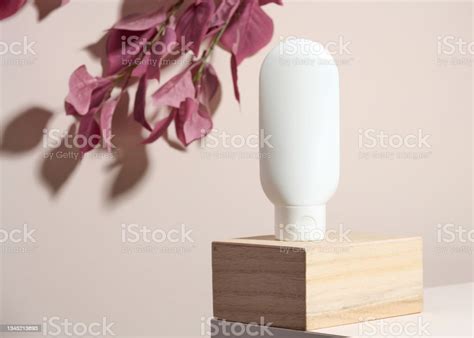 화장품을 위한 빈 흰색 플라스틱 튜브는 그림자가 있는 베이지 색 배경의 나무 연단에 서 있습니다 크림 샴푸 액체 물질용 용기 0명에 대한 스톡 사진 및 기타 이미지 Istock