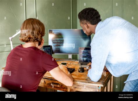 Two Young Programmers Working With Program Code Sitting At The