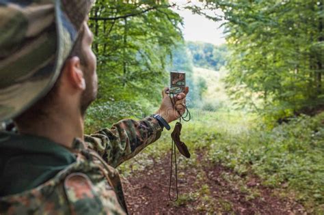 soldier using compass navigating in forest during operation stock image