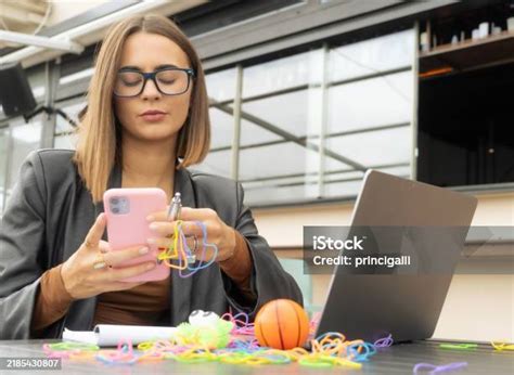 컴퓨터를 들고 있는 젊은 여성 검은 가죽 재킷을 입고 메모를 하고 집중을 위해 물건 고무줄 장난감 및 보조 장치를 사용합니다 20 24세에 대한 스톡 사진 및 기타 이미지