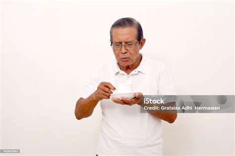 노인 아시아 남자가 커피 한 잔을 들고 서서 그것을 날려 버린다 흰색 배경에 고립 70 79세에 대한 스톡 사진 및 기타 이미지 70 79세 개념 개념과 주제