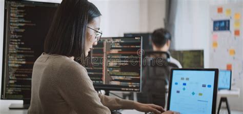 Asian Male Female Software Developer Coding Program On Desktop