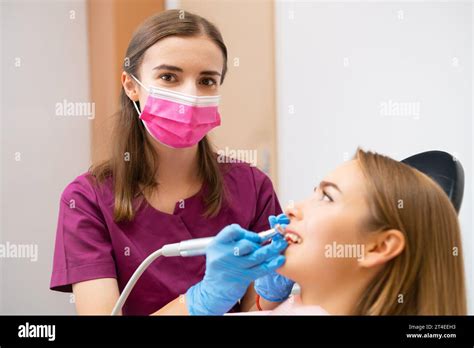 A Dentist Is Performing A Teeth Grinding Procedure On A Lovely Woman To