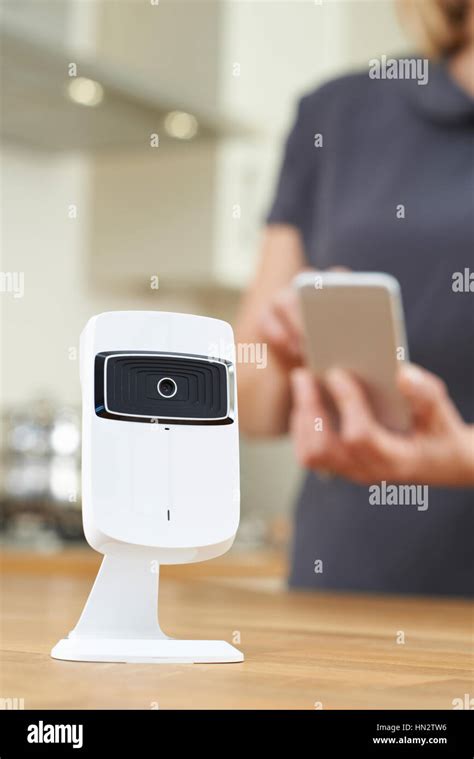 Woman Controlling Smart Security Camera Using App On Mobile Phone Stock Photo Alamy