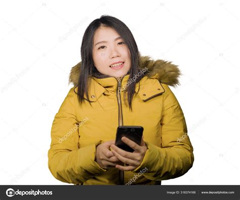 Young Beautiful And Happy Asian Korean Woman In Warm Yellow Feather