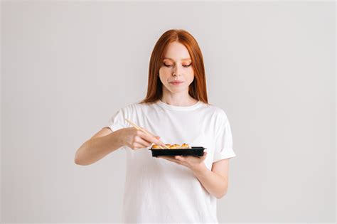 흰색 고립 된 배경에 서 젓가락맛있는 초밥 롤을 들고 매력적인 젊은 여성의 스튜디오 샷 먹기에 대한 스톡 사진 및 기타 이미지 먹기 여자 귀여운 Istock