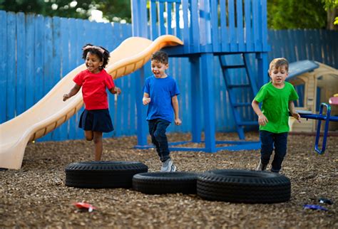 세 명의 미취학 아동이 어린이집 놀이터에서 함께 콩주머니 던지기 게임을 하고 있다 아이에 대한 스톡 사진 및 기타 이미지 아이 운동장 유치원 Istock