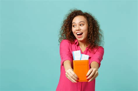 스튜디오에서 파란색 청록색 벽 배경에 고립 여권 탑승권 티켓을 들고 분홍색 캐주얼 옷에 놀란 아프리카 소녀 사람들은 진심으로 감정 라이프 스타일 개념입니다 복사 공간을 모의