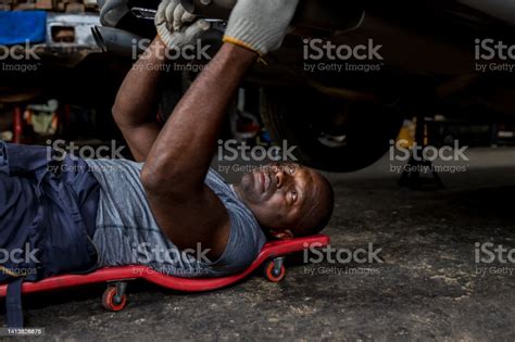 자동차 서비스 차고에서 누워서 차 밑에서 일하는 정비사 기술자 차량 유지 보수 및 자동차 자동차 차고에서 자동차 아래 확인 45 49세에 대한 스톡 사진 및 기타 이미지