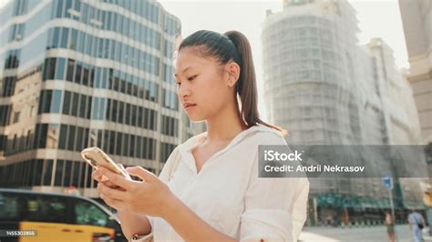 젊은 여자는 도로 옆에 서서 휴대 전화를 사용합니다 택시를 기다리는 소녀 가까운에 대한 스톡 사진 및 기타 이미지 가까운 갈색 머리 거리 Istock