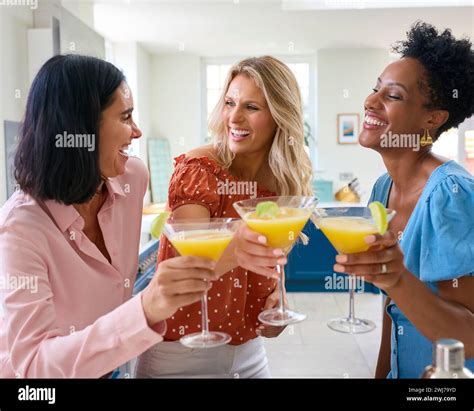 Three Mature Female Friends At Home Celebrating With Cocktails Together