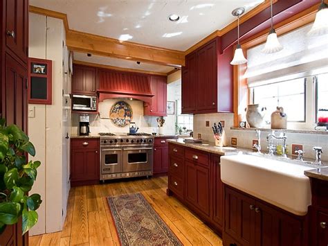 A Kitchen With Wooden Floors And Red Cabinets