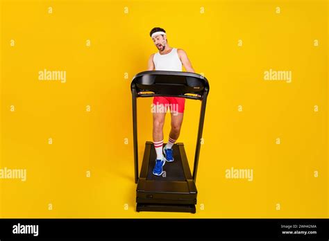 Full Length Photo Of Shocked Funky Guy Sportswear Running Too Fast Treadmill Isolated Yellow
